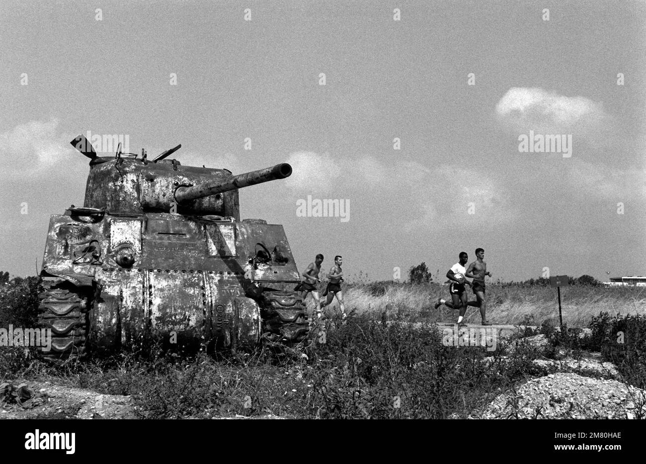 Marines run past the ruins of a tank during their daily physical ...