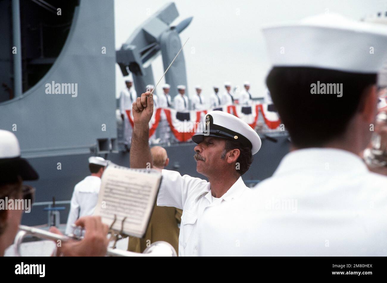 A Navy conductor directs the band playing the commissioning ceremony ...