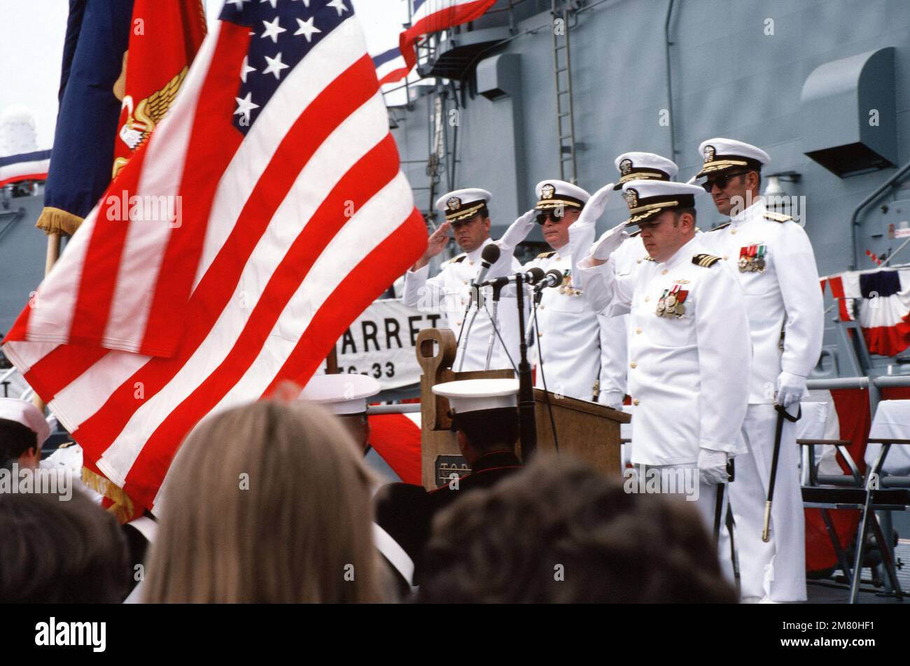 Officers on the speakers platform salute the flag during the ...