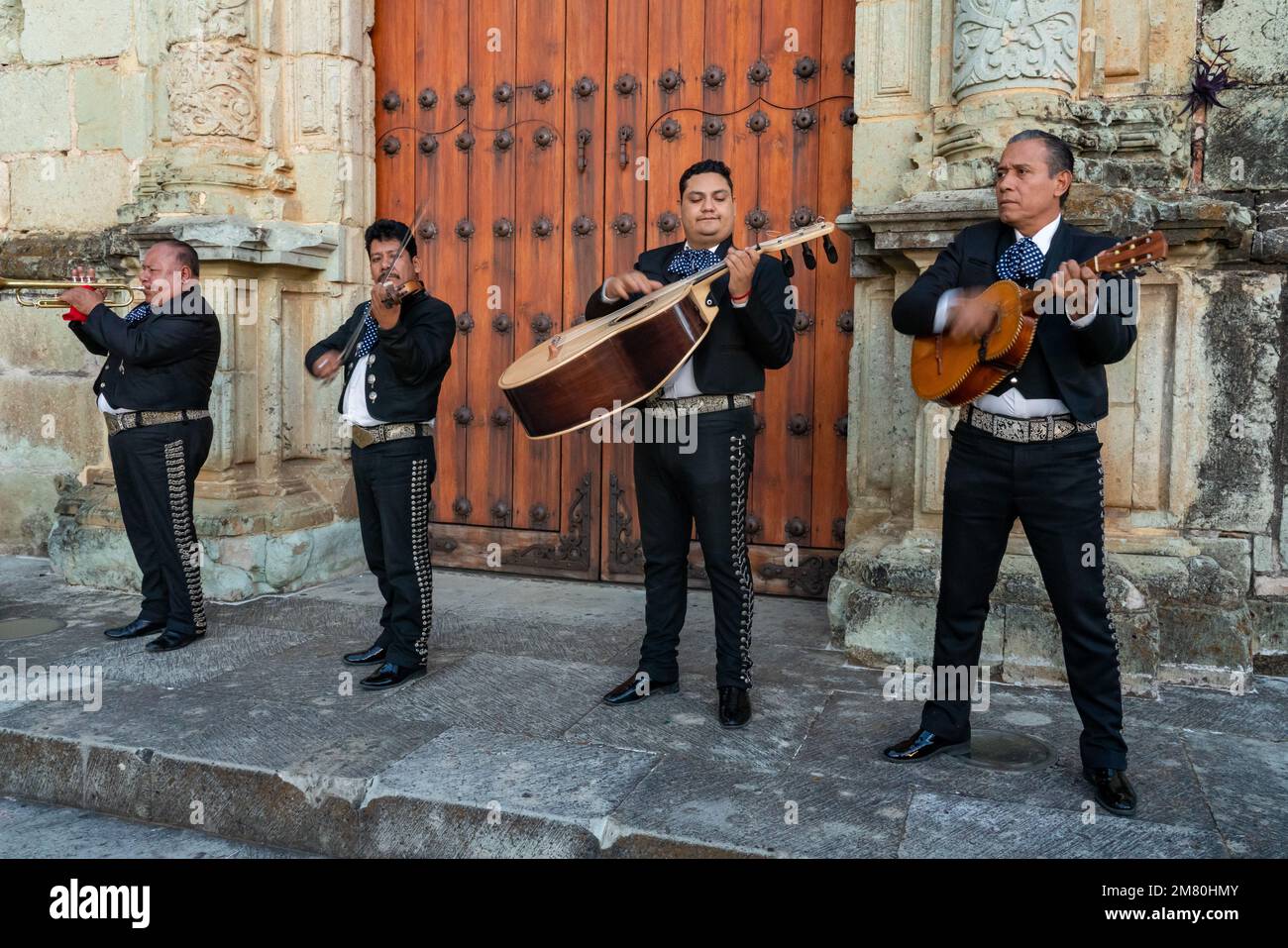 A mariachi band in charro costumes performs on the steps of the Church ...