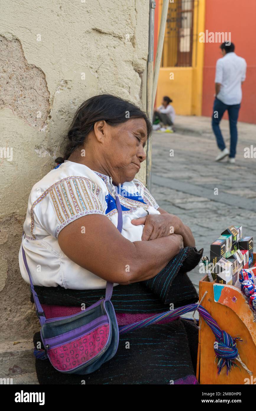 An indigenous street vendor naps on the street in Oaxaca, Mexico. These ...