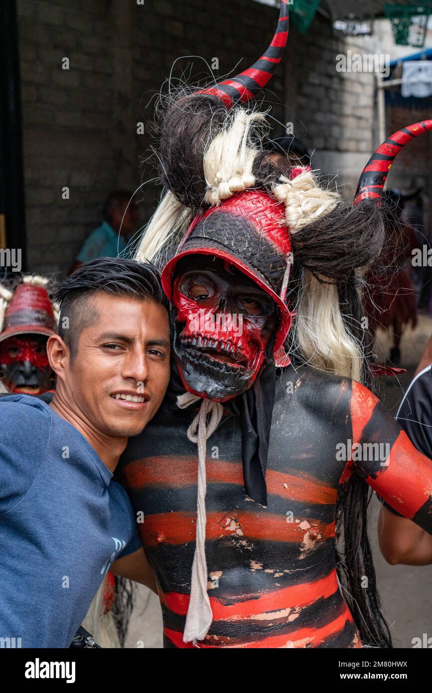 A man posing with a friend in a cachudo costume with mask & horns at ...