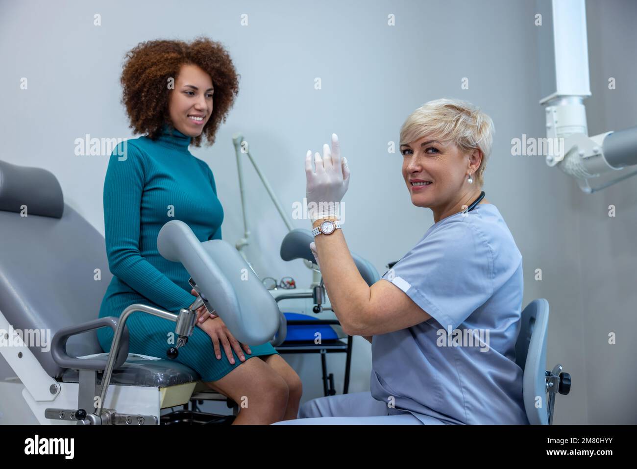 Gynecologist working with a woman sitting on a examination chair Stock ...