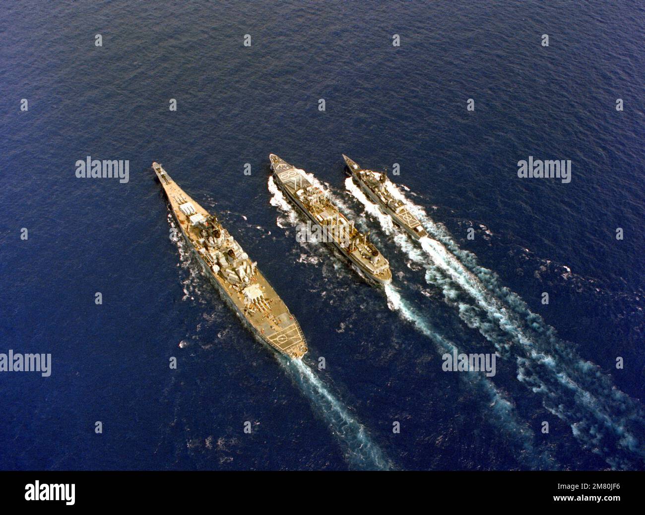 The battleship USS NEW JERSEY (BB-62), left, travels alongside the ...