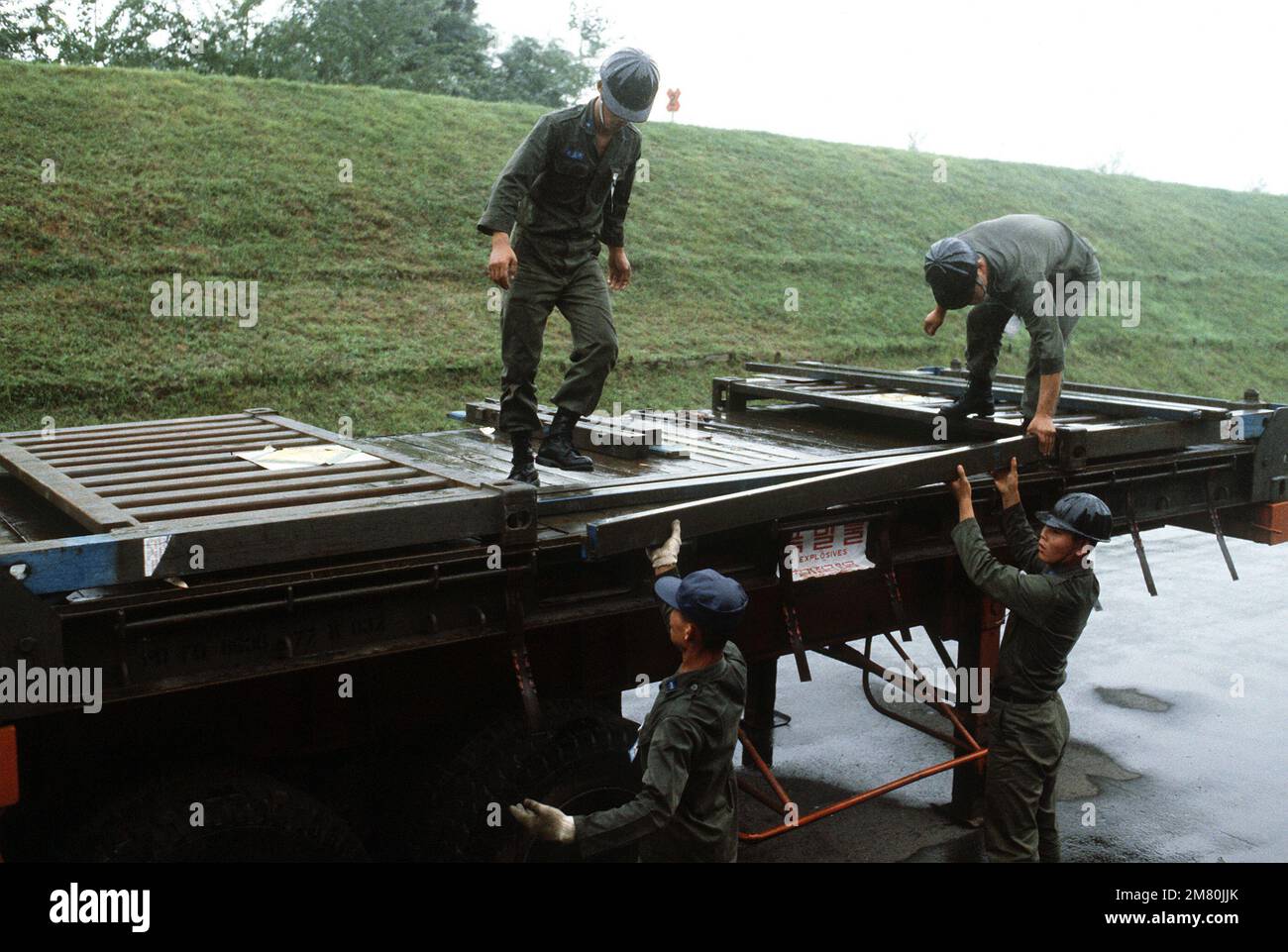 Korean troops fold up the braces of an open flatrack container after ...