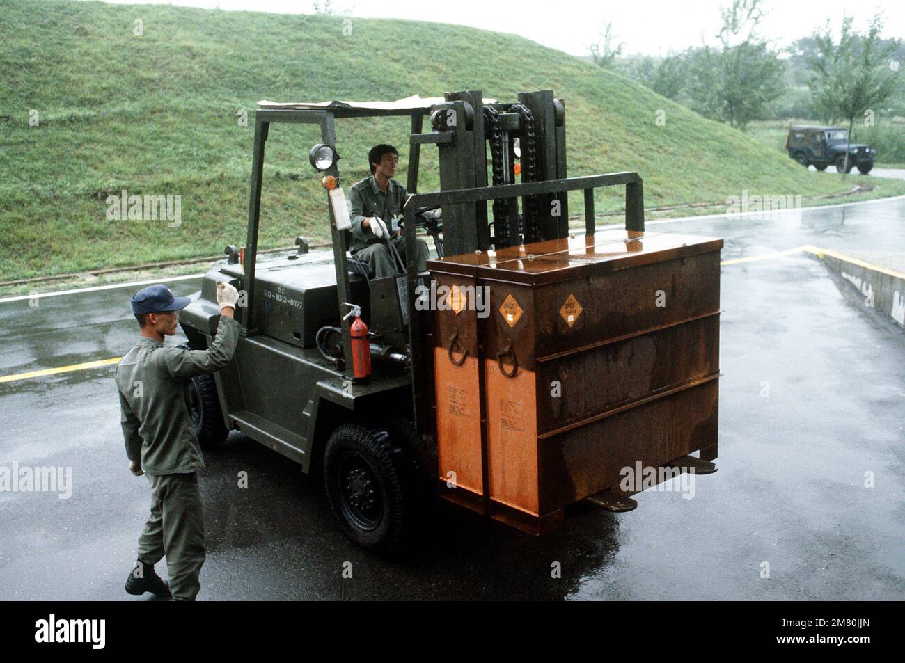 Korean troops use a forklift to remove crates of 30mm munitions from an ...