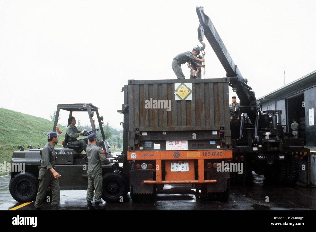 Korean troops use a truck crane to unload an open flatrack container ...