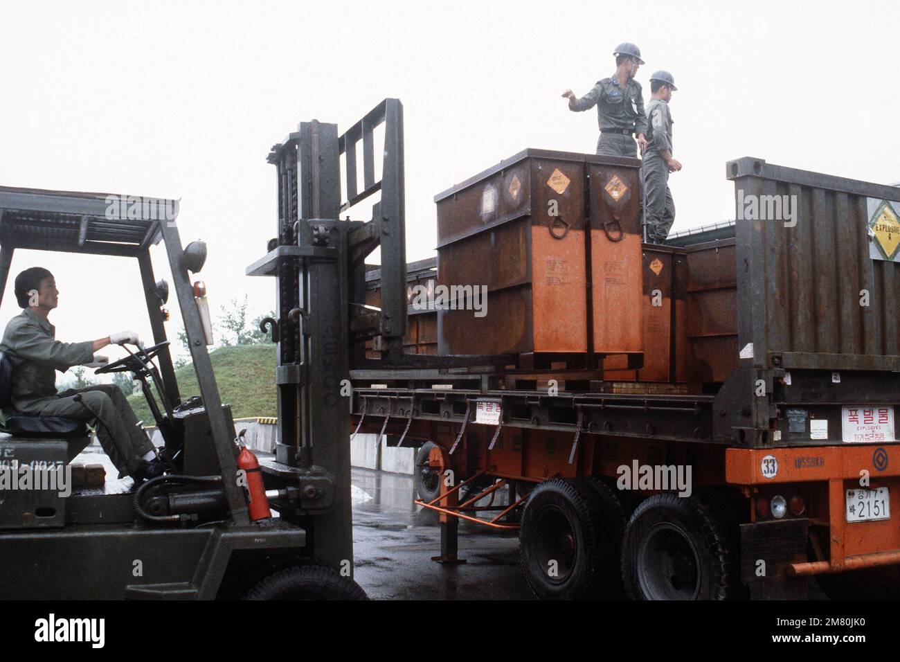Korean troops use a forklift to remove crates of 30mm munitions from an ...