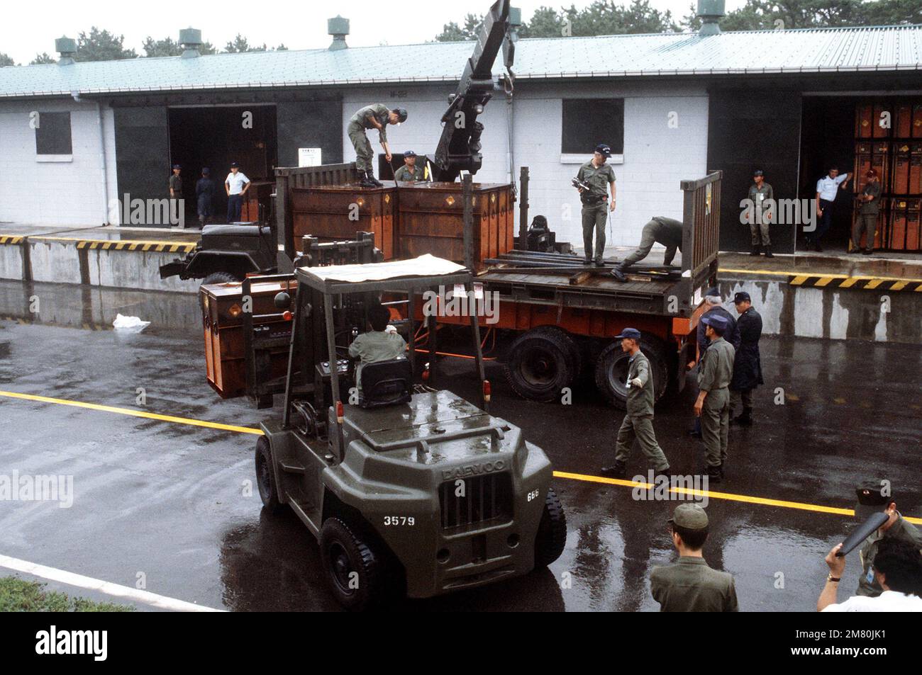 Korean troops use a forklift and a truck to remove crates of 30mm ...