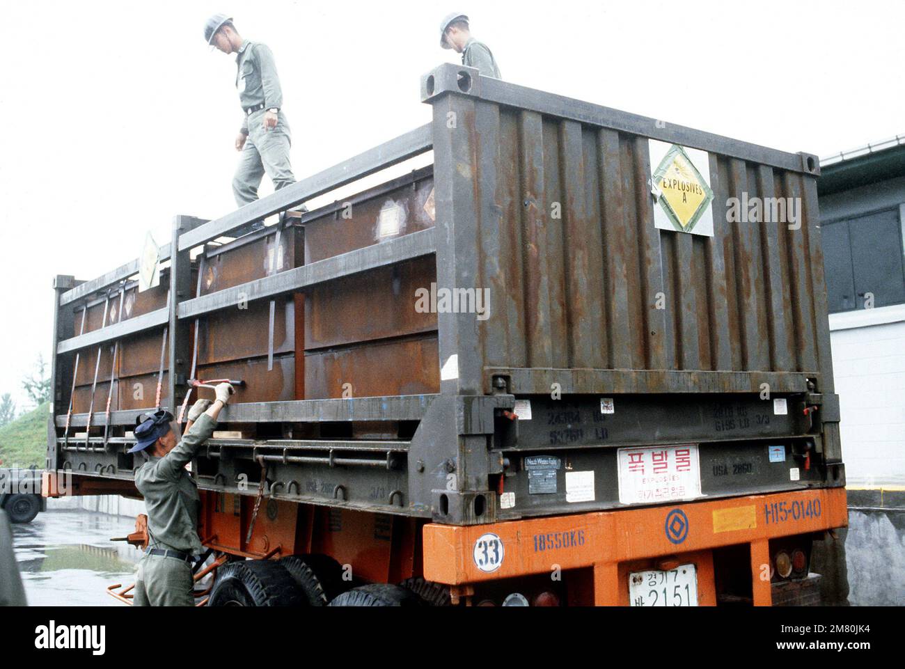 Korean troops cut the metal straps of an open flatrack container ...