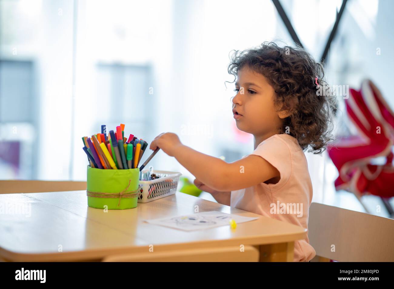 Cute little girl drawing in a play room Stock Photo - Alamy