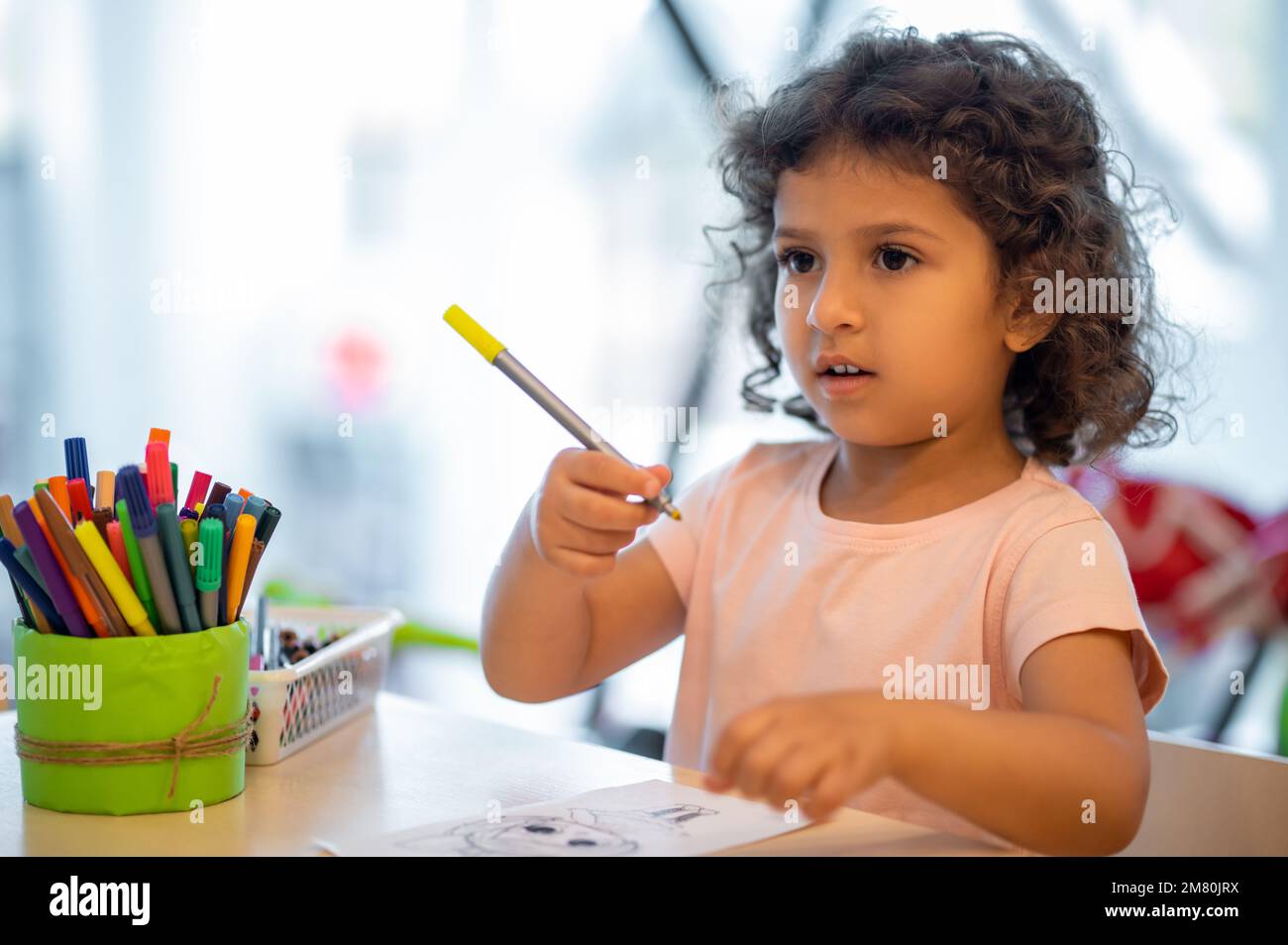 Cute little girl drawing in a play room Stock Photo - Alamy