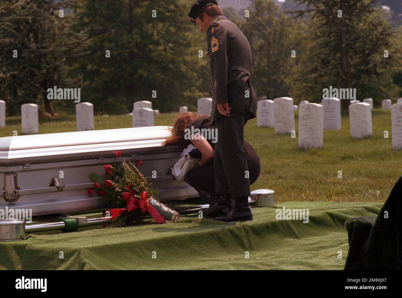 Mrs. T. Bates III is comforted by her husband as she kneels next to the ...