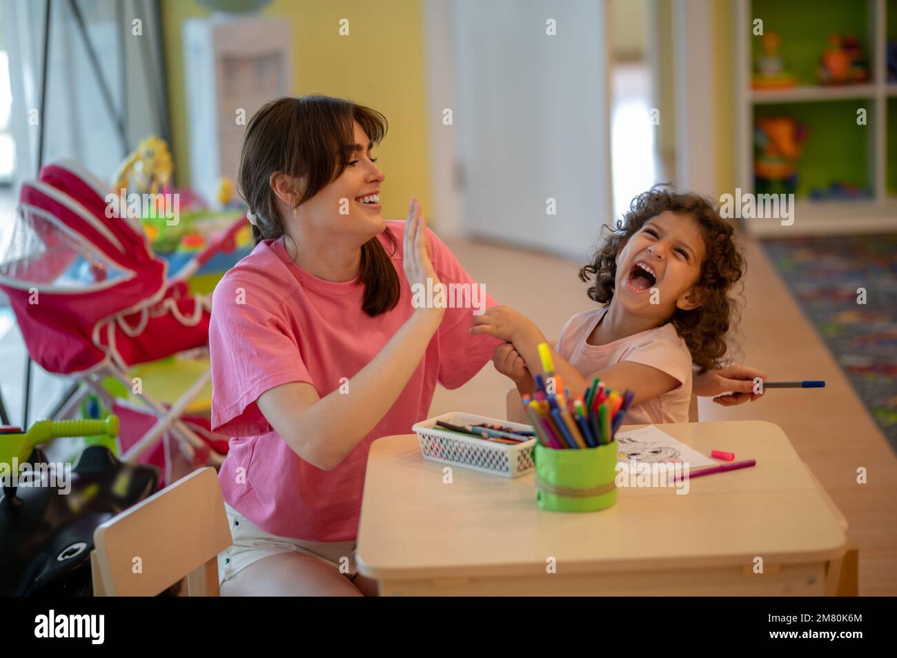 Mom and kid in a play room, the kid crying Stock Photo - Alamy