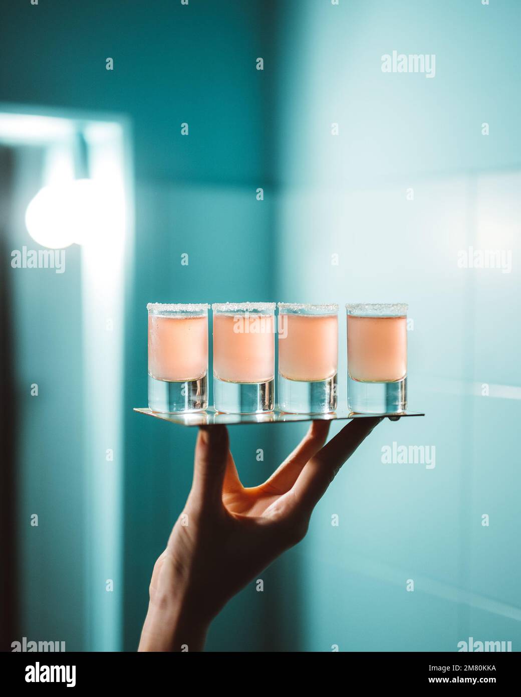 Bartender's hand holding cocktails shots in restaurant, pub or night ...