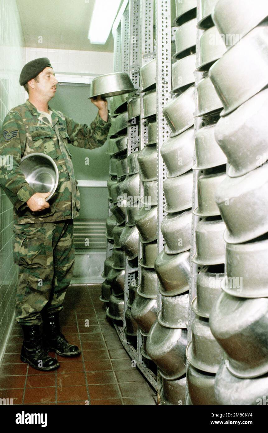 SSGT Allen takes dishes from the rack as preparations are made to feed ...