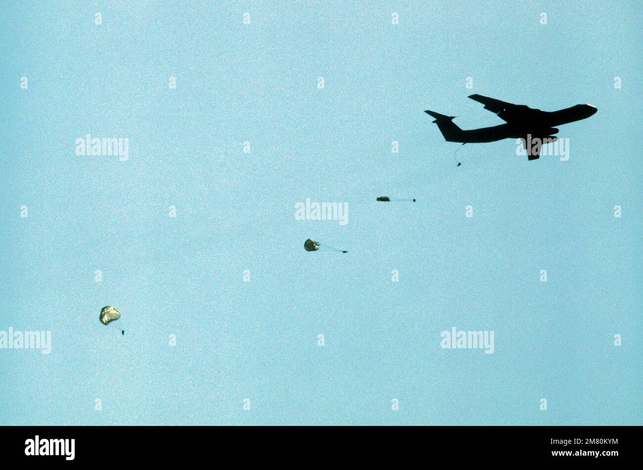 Paratroopers jump from a C-141B Starlifter aircraft during a training ...