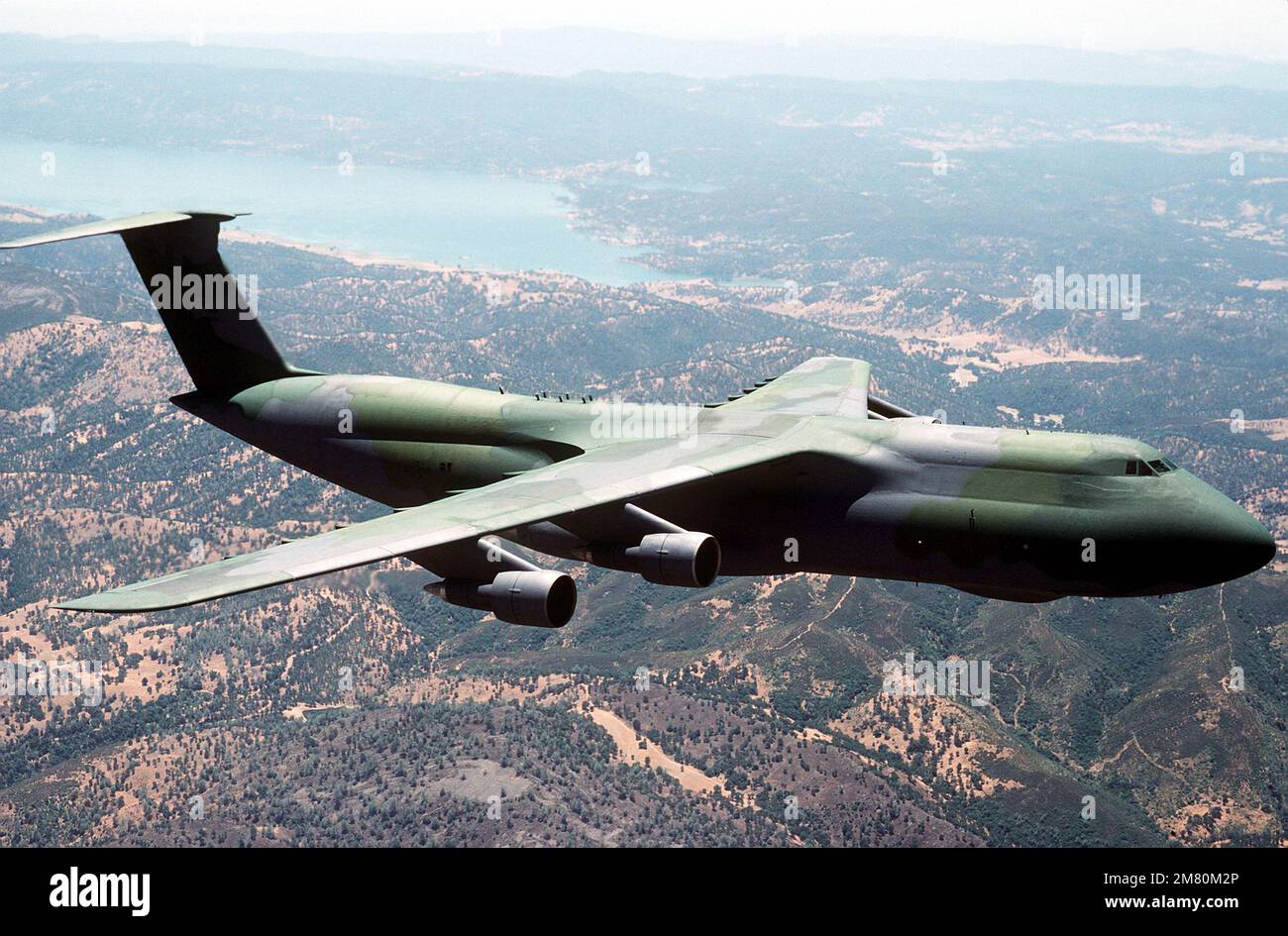 An air-to-air right side view of a C-5 Galaxy aircraft, in a camouflage ...