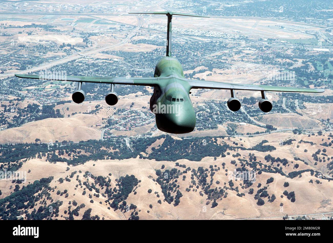 An air-to-air front view of a C-5 Galaxy aircraft, in a camouflage ...