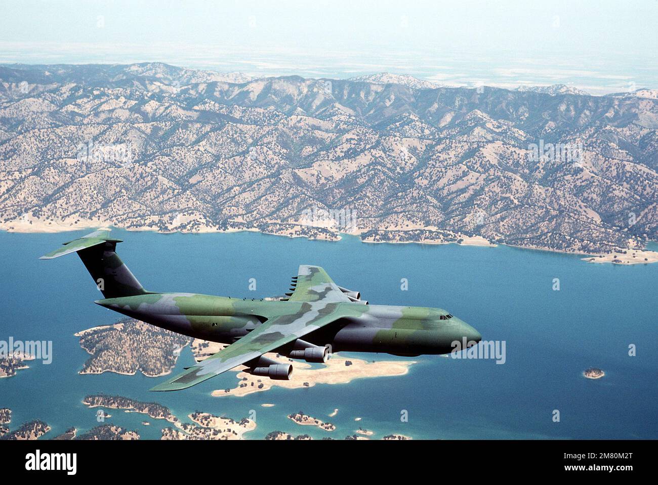 An air-to-air right side view of a C-5 Galaxy aircraft, in a camouflage ...