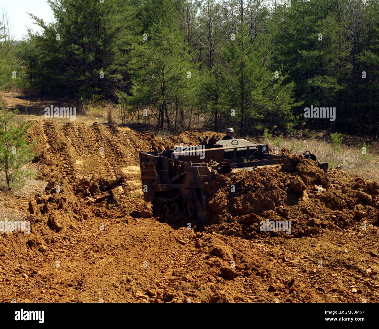 A right front view of an M-9 Armored Combat Earthmover (ACE) digging a ...