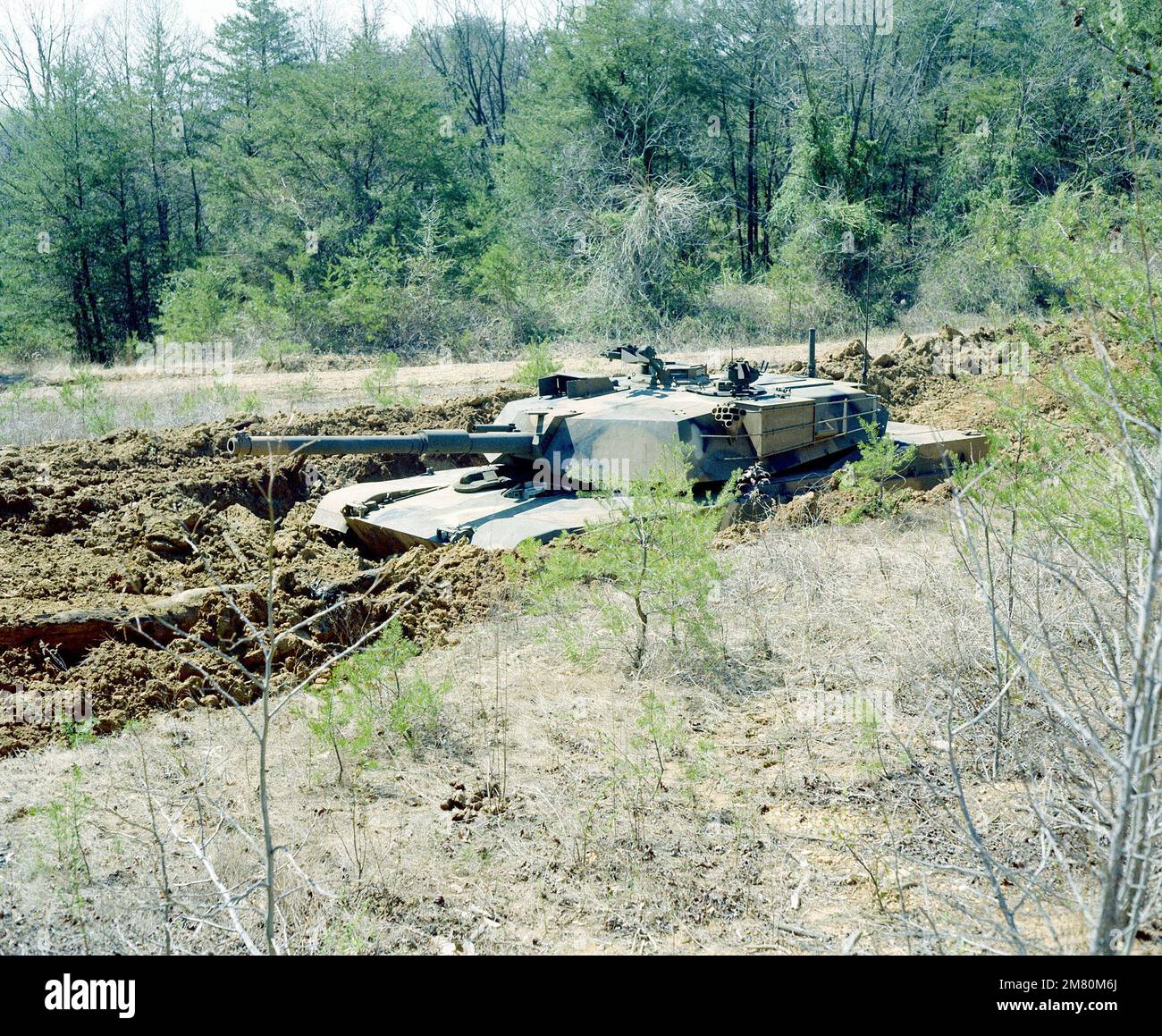 A left front view of an M-1 tank in a defilade position created by an M ...