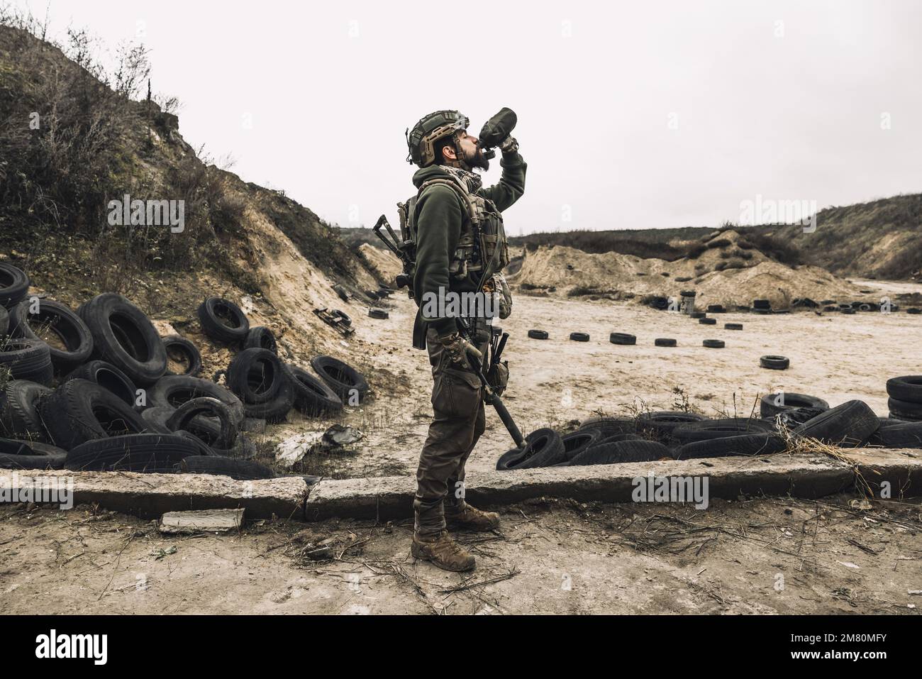 Soldier in military uniform drinking from flask Stock Photo - Alamy