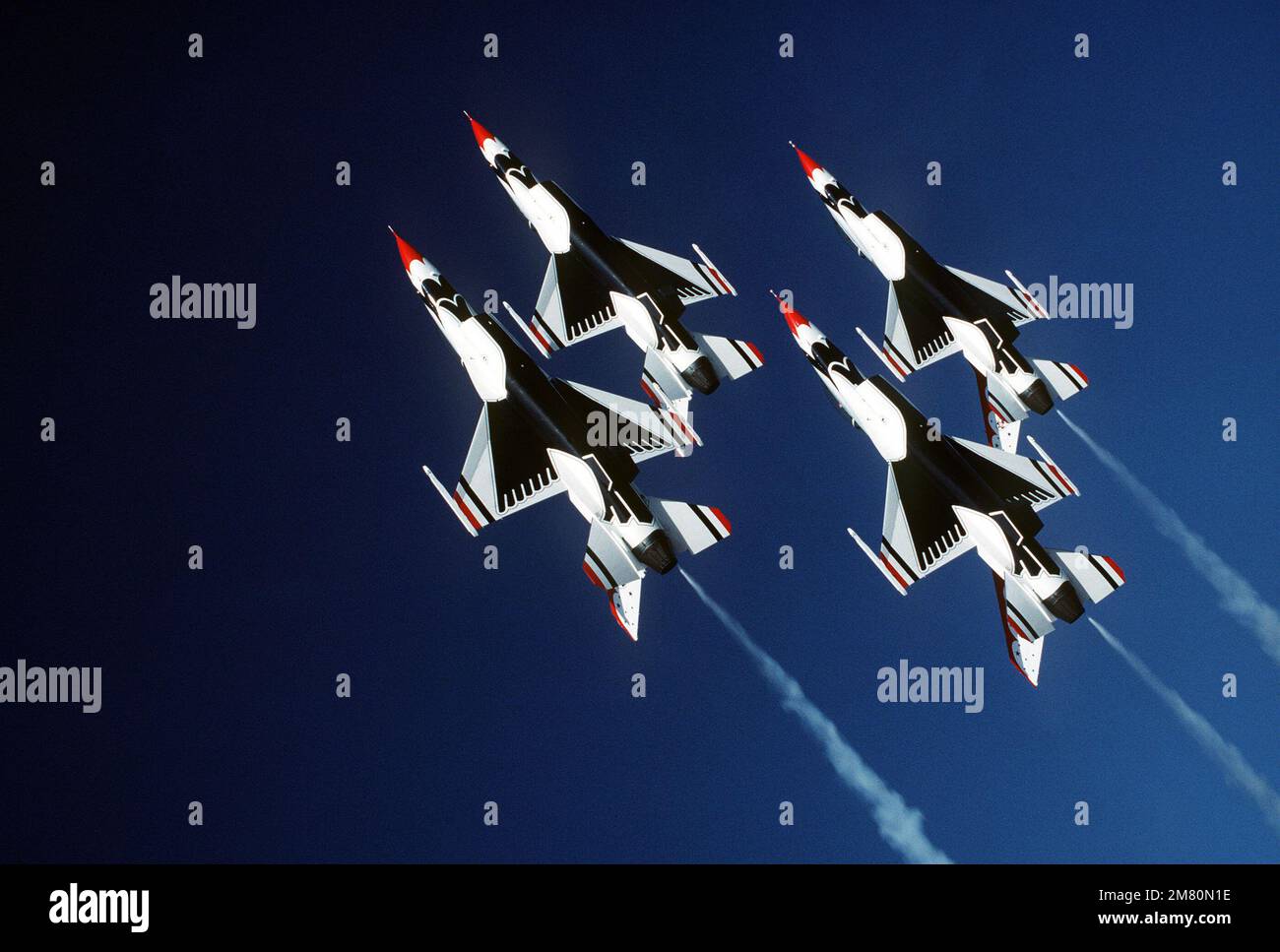 An air-to-air underside view of four F-16 Fighting Falcon aircraft of ...