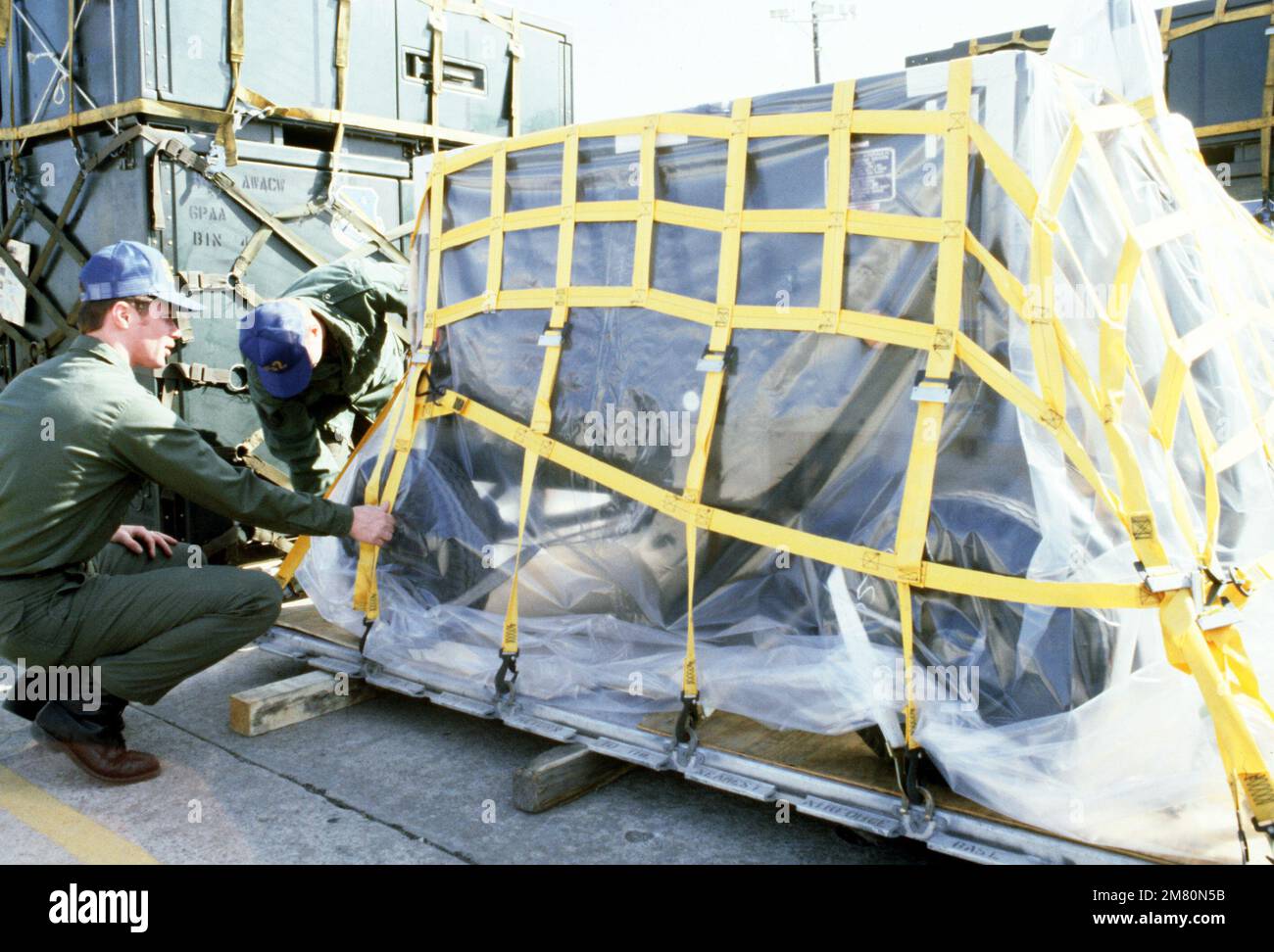 Air Force personnel prepare cargo for deployment aboard C-5A Galaxy and ...