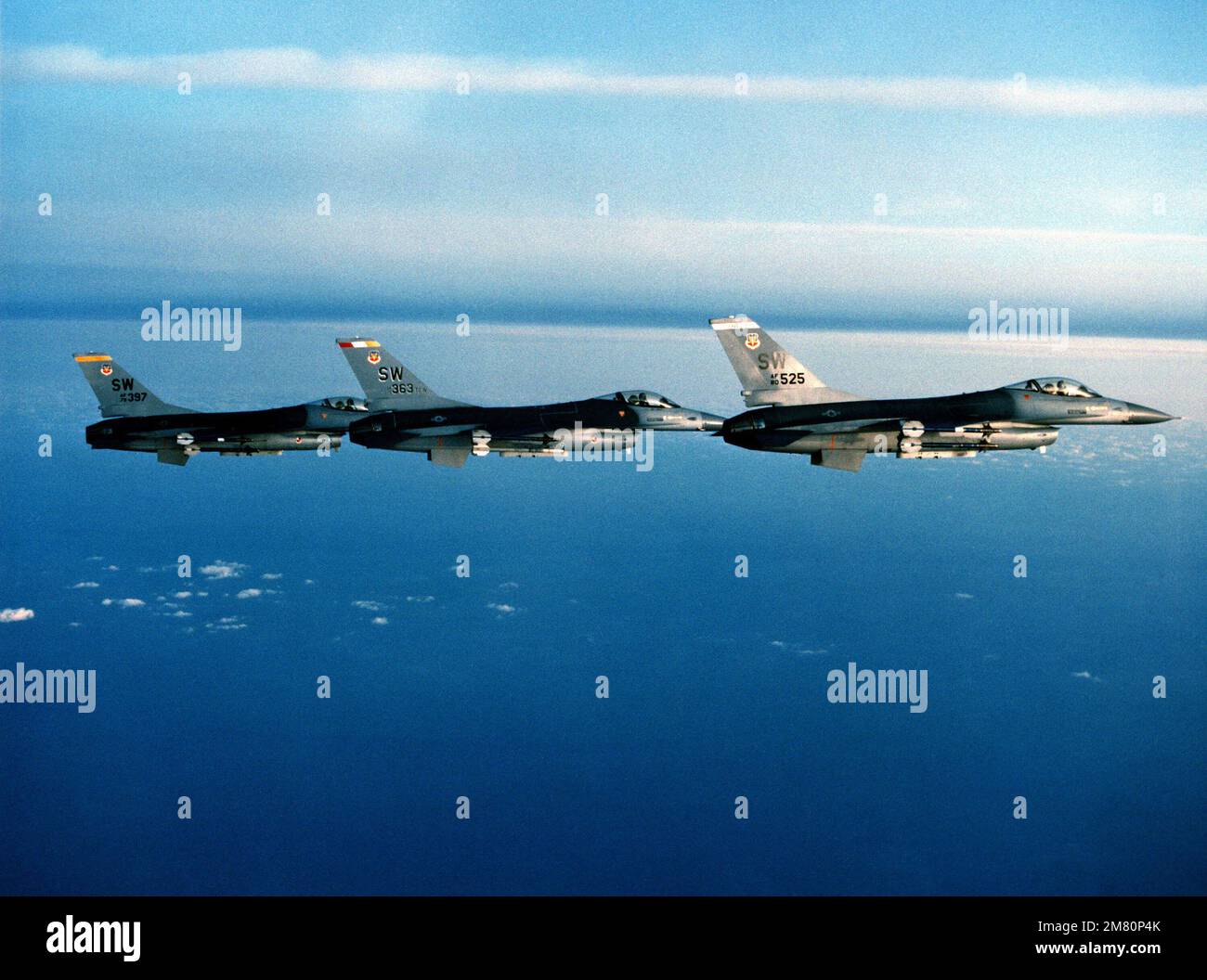 An air-to-air right front view of three F-16A Fighting Falcon aircraft ...