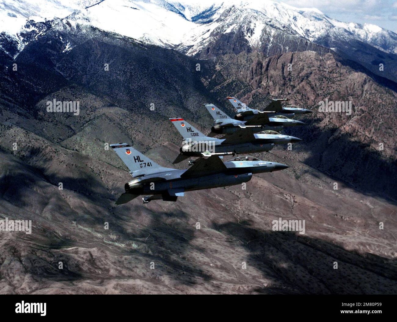 An air-to-air right side view of four F-16A Fighting Falcon aircraft ...