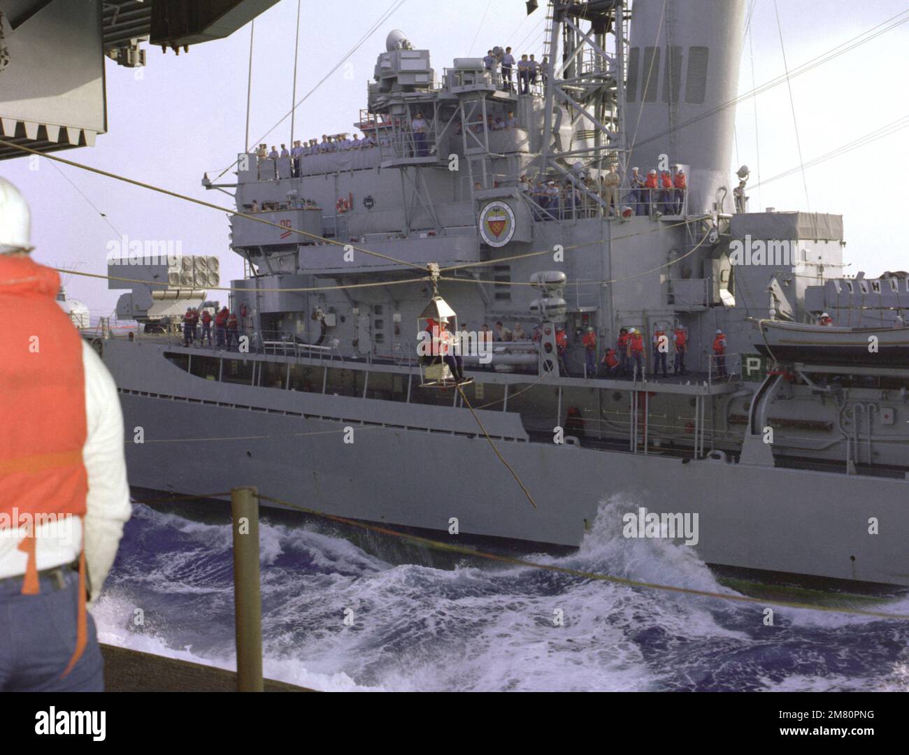 Secretary of the Navy John F. Lehman Jr. is highlined from the nuclear ...