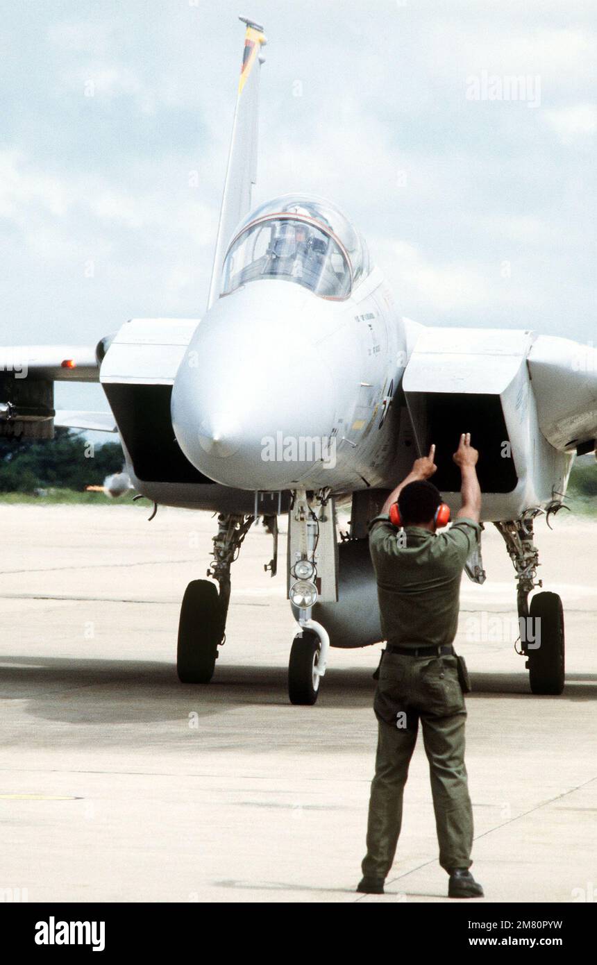 An 18th Tactical Fighter Wing ground crewman guides an F-15 Eagle ...