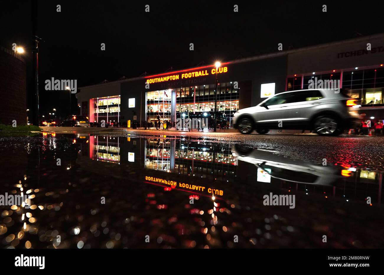 A reflection of the stadium is shown in a rain puddle before the ...