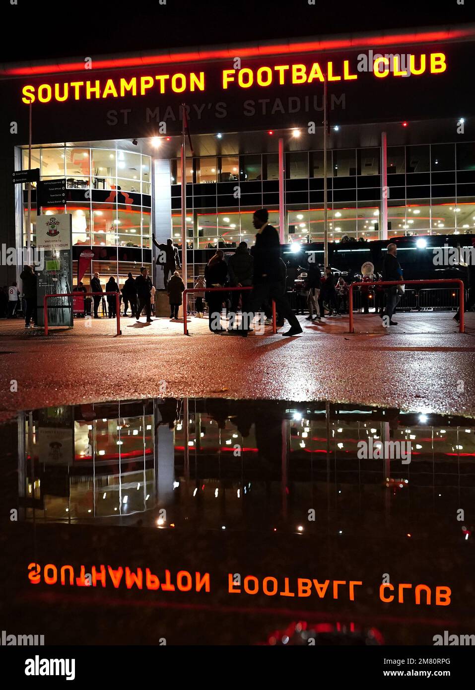 A reflection of the stadium is shown in a rain puddle before the ...