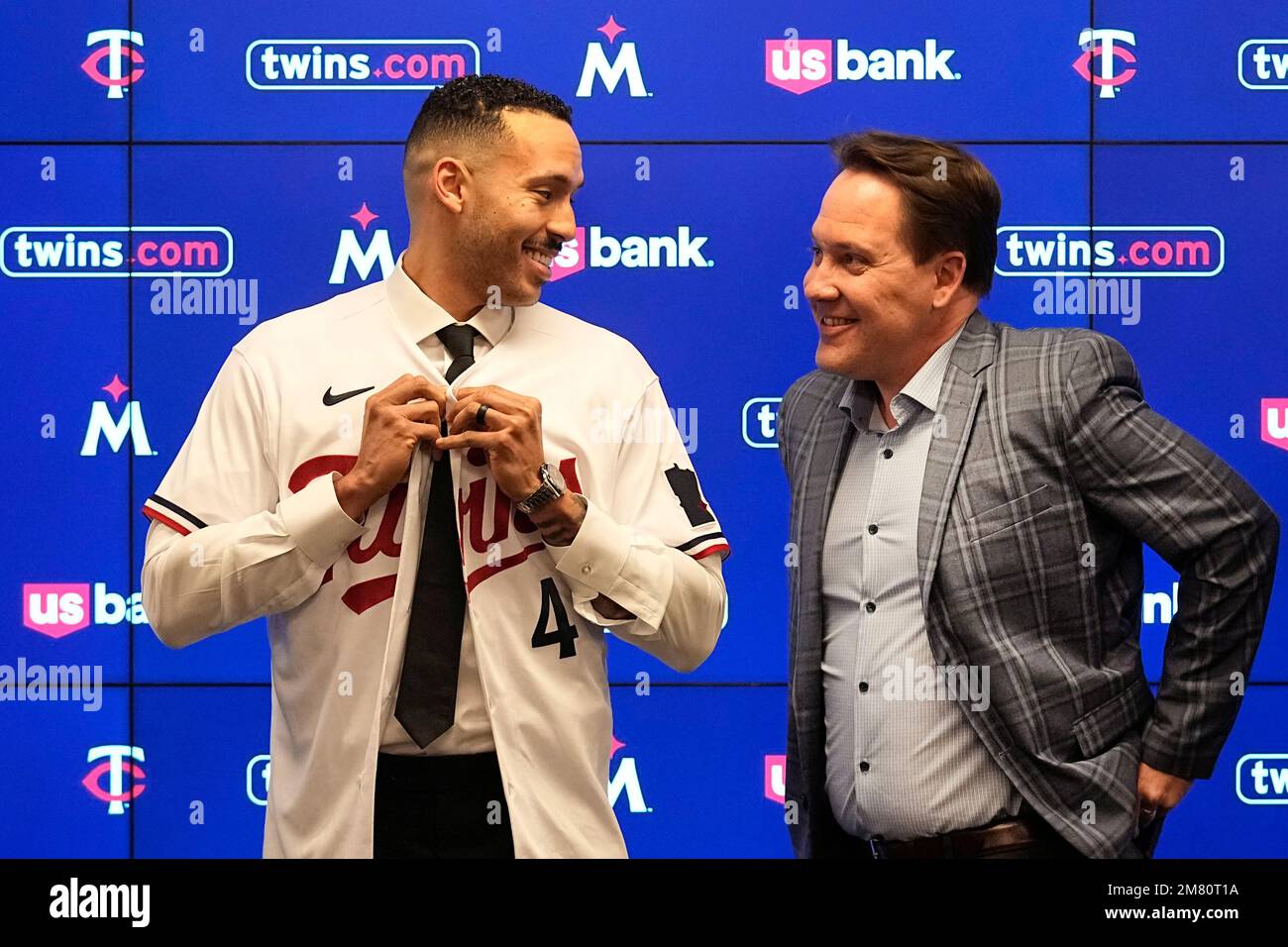 Minnesota Twins' Carlos Correa, left, puts on a team jersey alongside ...