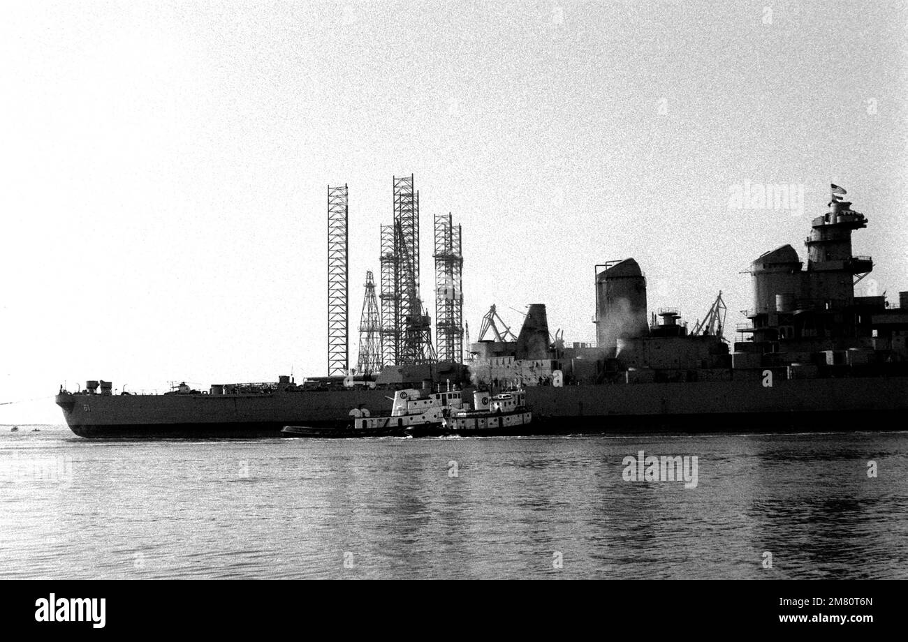 Tugboats assists the battleship USS IOWA (BB-61) into the Ingalls Shipbuilding shipyard. The ...