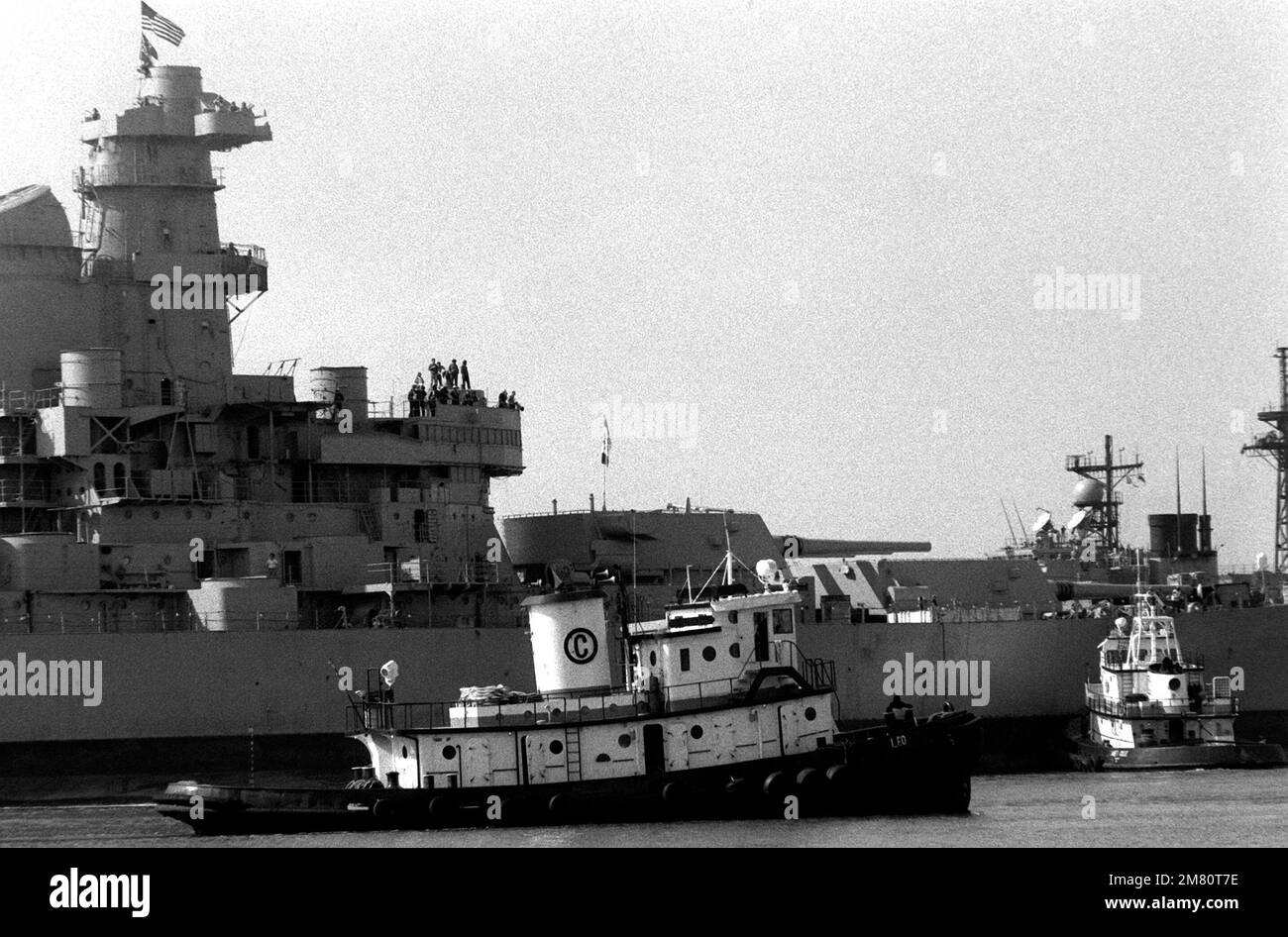Tugboats assists the battleship USS IOWA (BB-61) into the Ingalls Shipbuilding shipyard. The ...