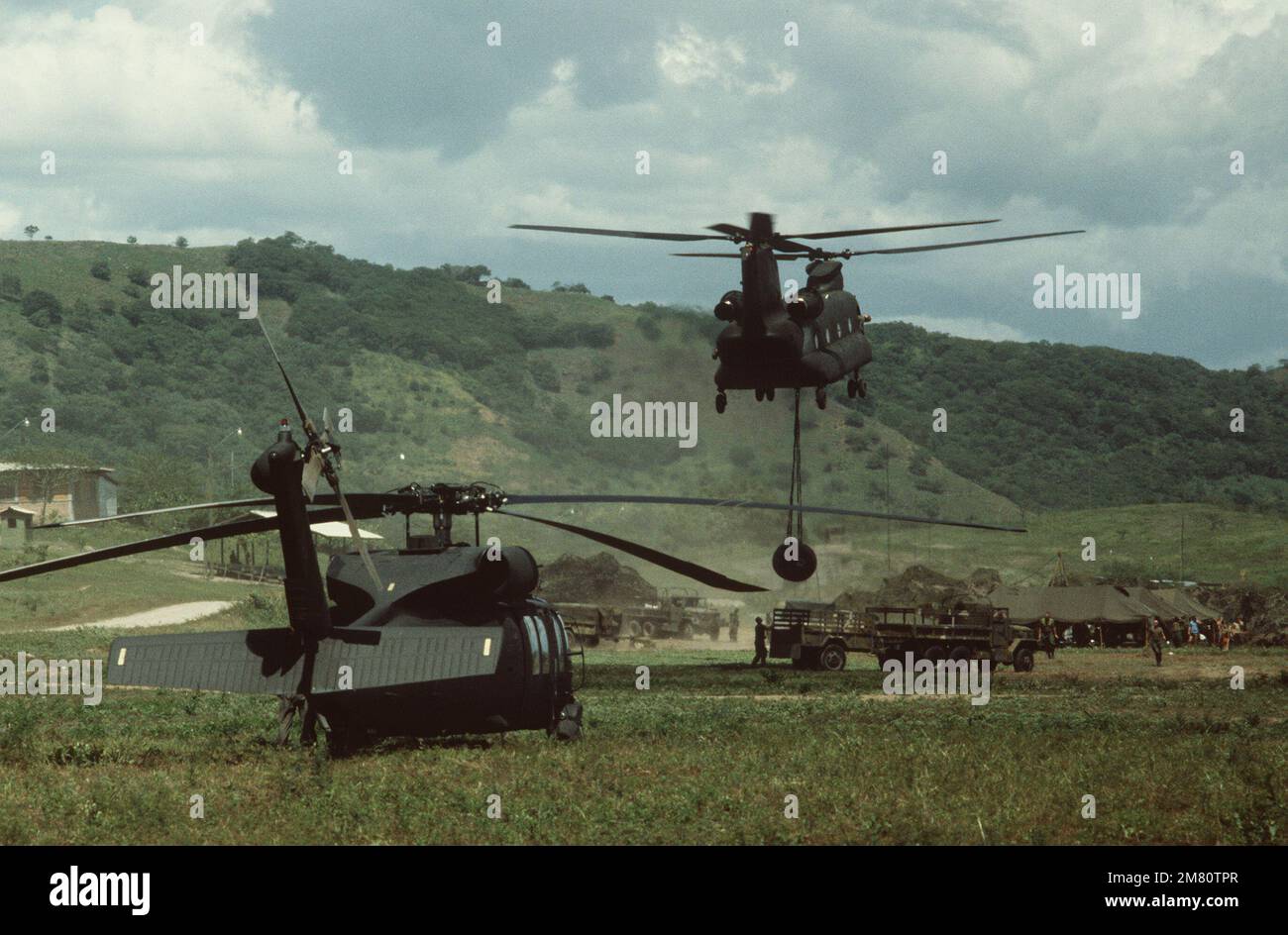 A rear view of a CH-47 Chinook helicopter as it lifts a piece of ...