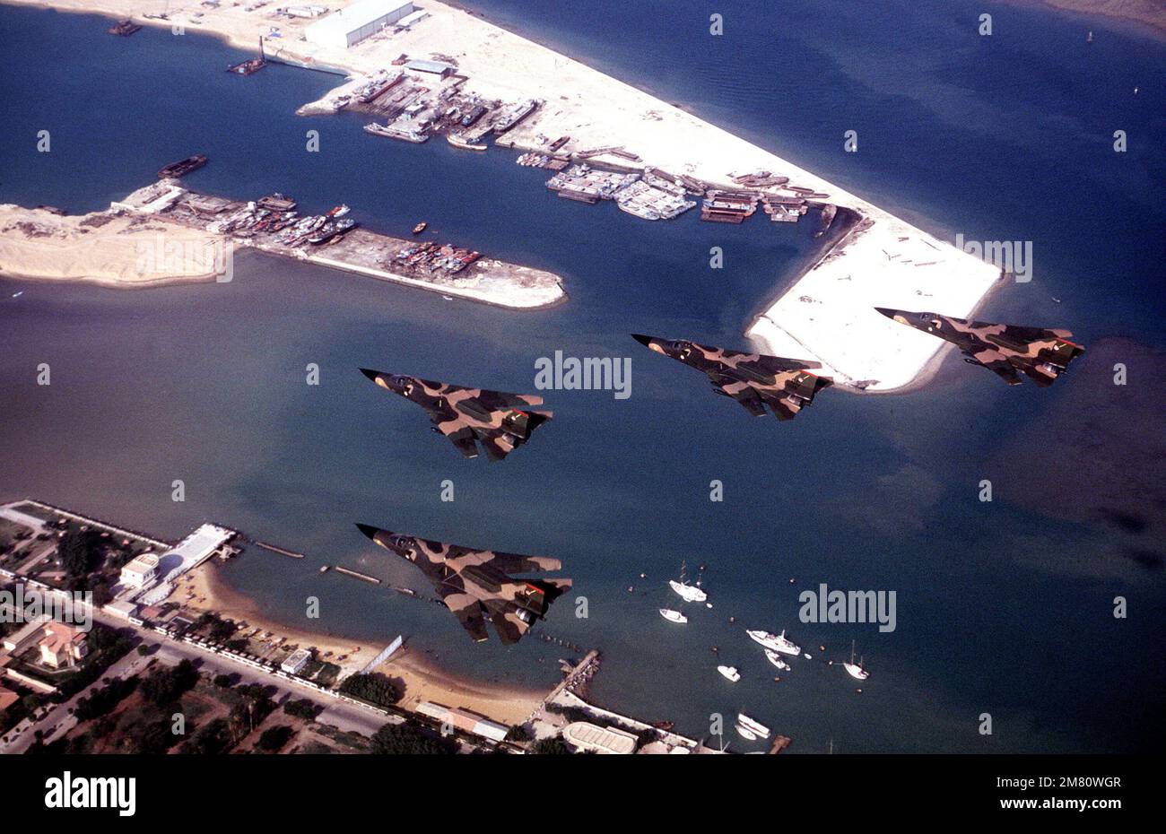 An air-to-air left side view of four F-111 aircraft as they fly over ...