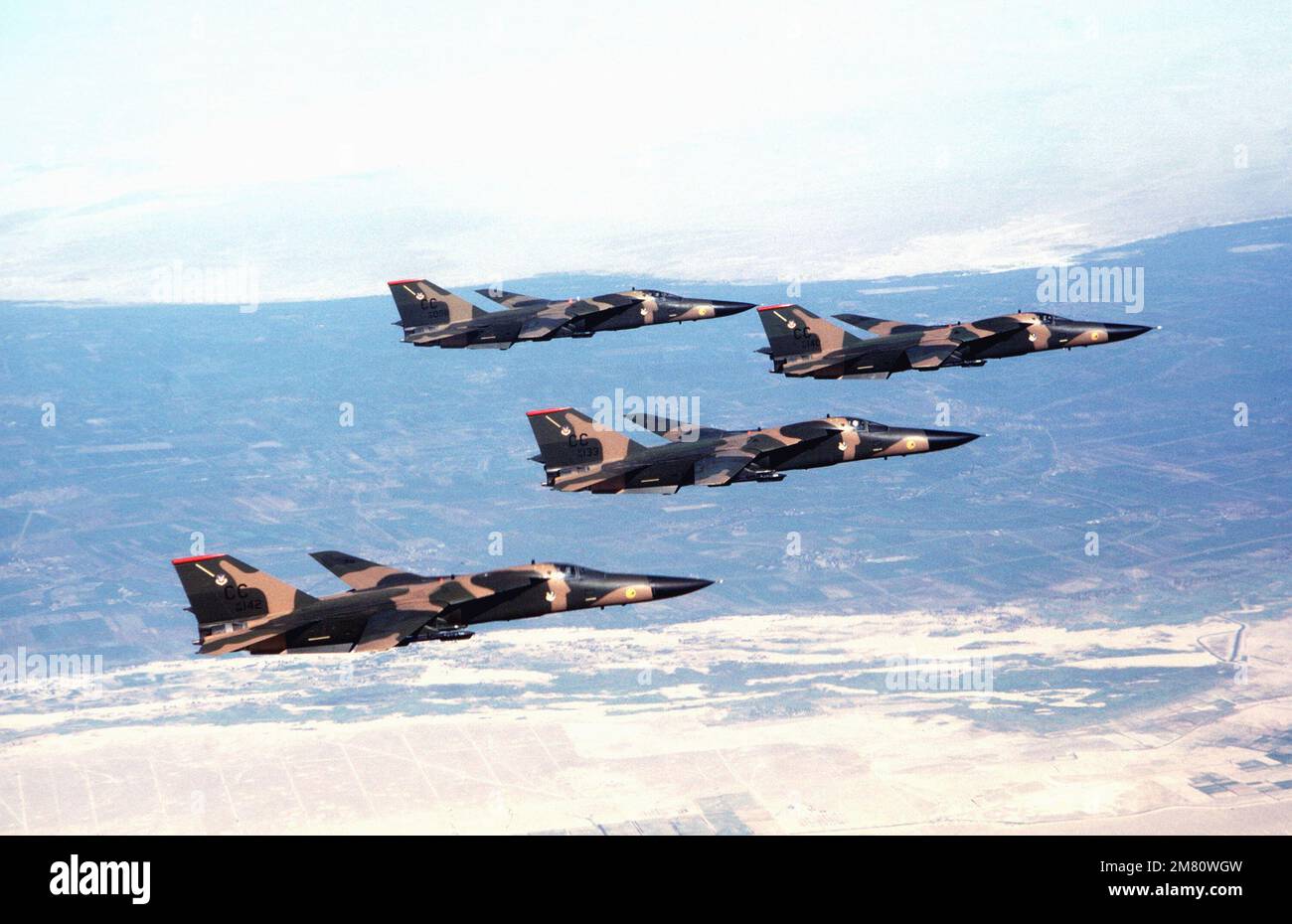 An air-to-air right side view of four F-111 aircraft in use during ...