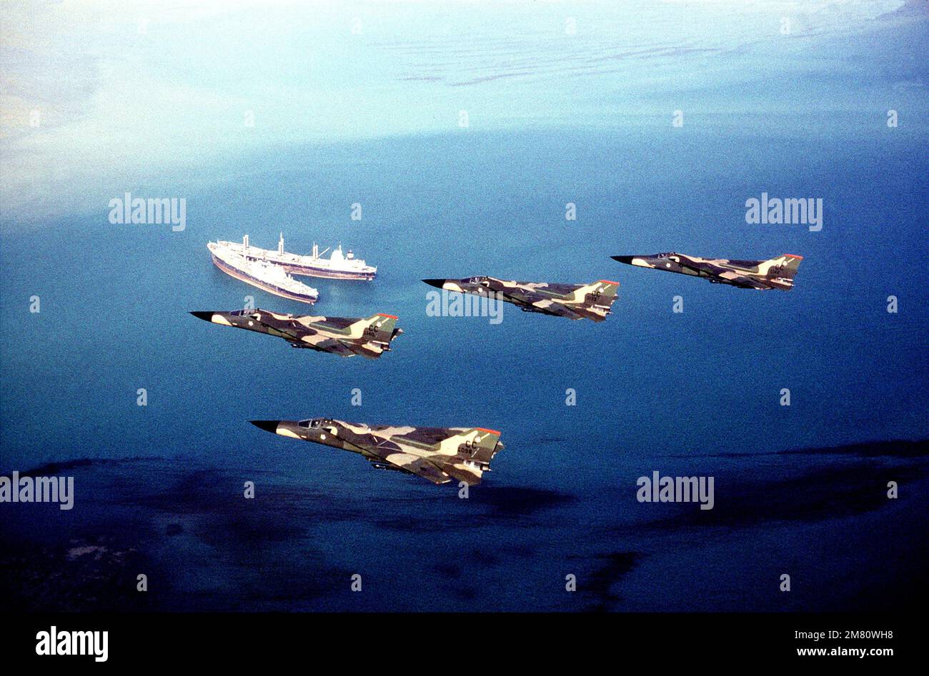 An air-to-air left side view of four F-111 aircraft as they fly over ...