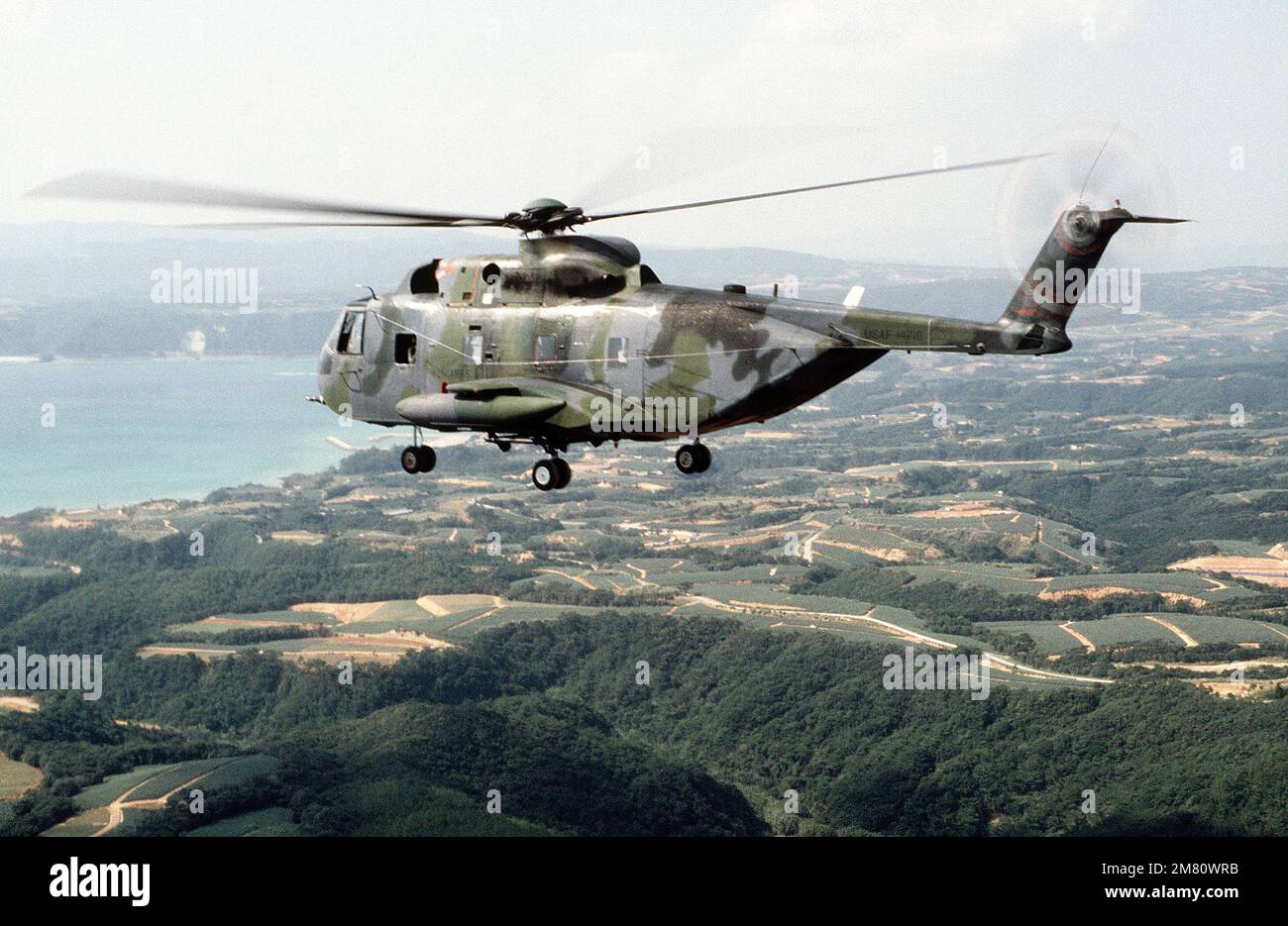 An air-to-air left side view of an HH-3E helicopter assigned to the ...