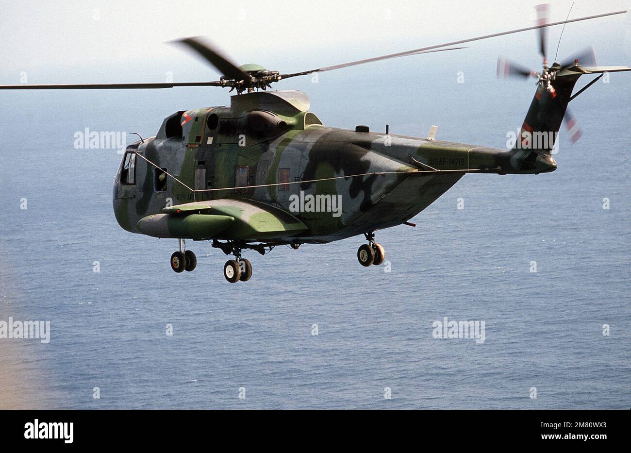 An air-to-air left rear view of an HH-3E helicopter assigned to the ...