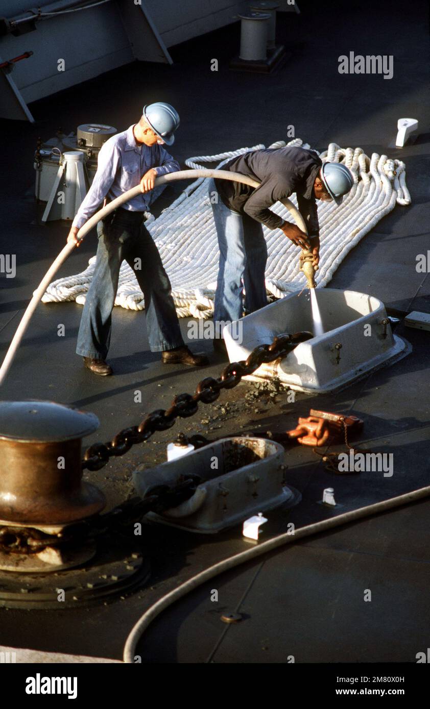 Crewmen hose down the anchor chain of the guided missile frigate USS ...