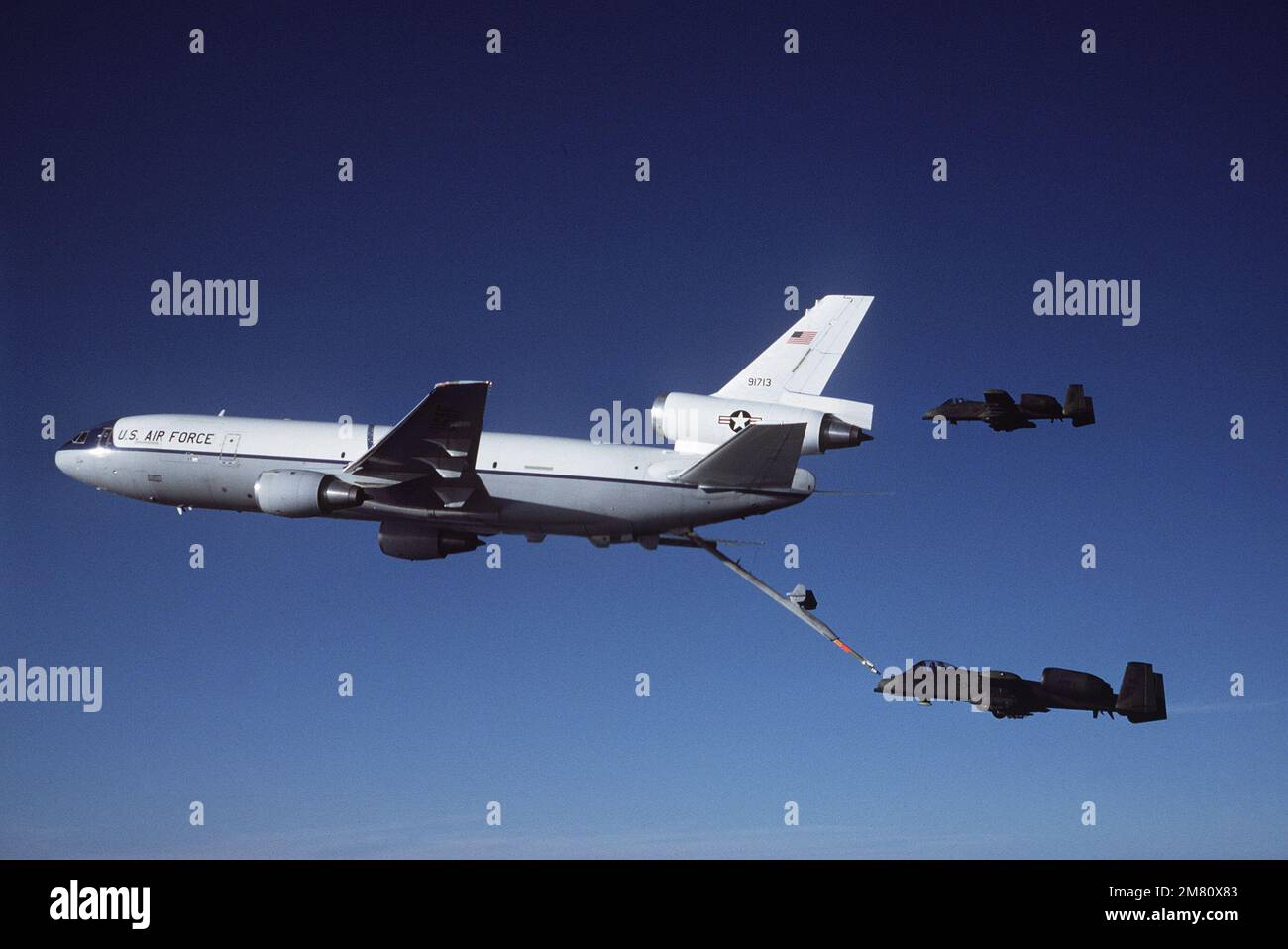 An air-to-air left side view of a KC-10 Extender aircraft refueling an ...
