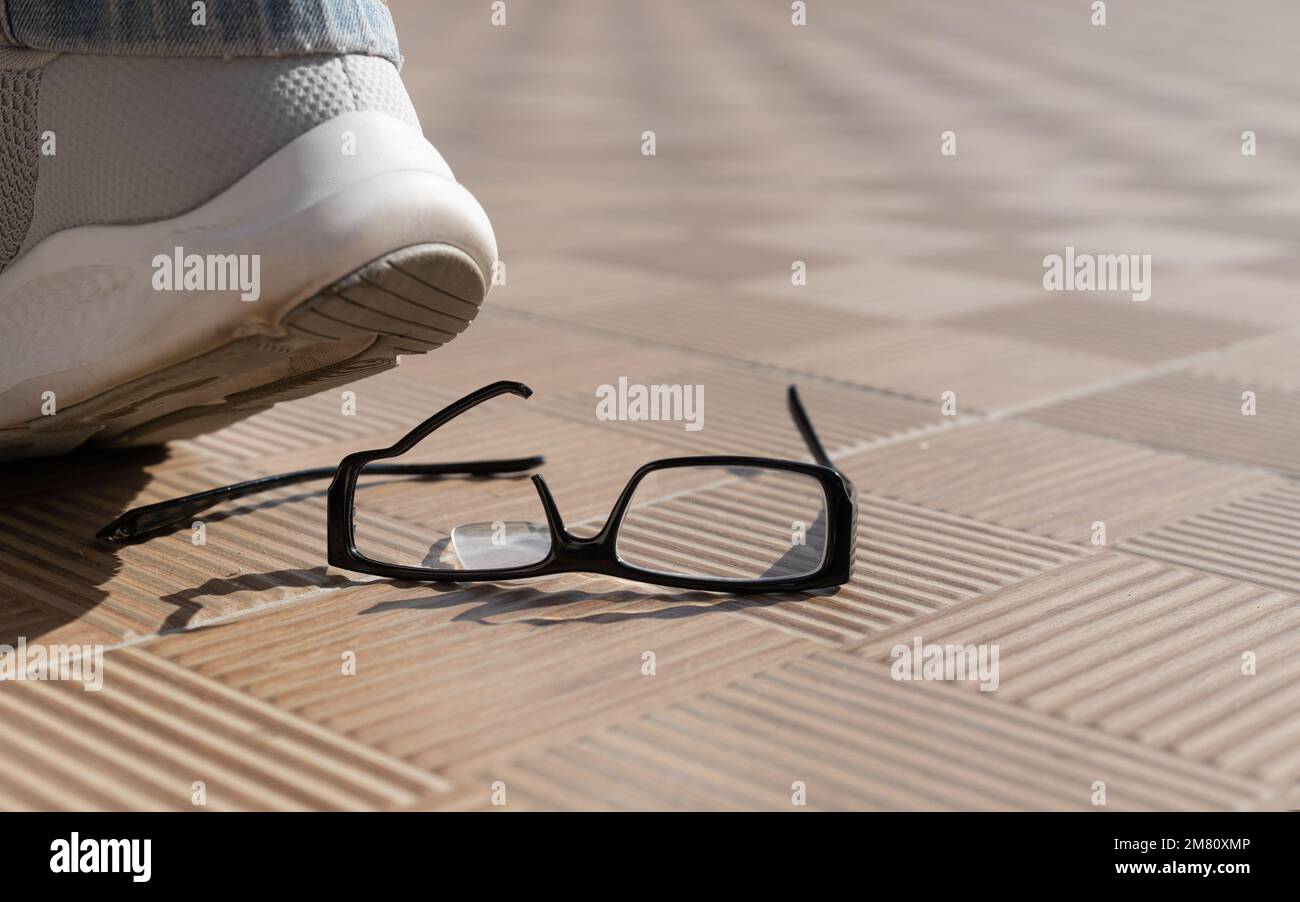 foot stepped on glasses. accident on st. broken glasses on street tiles ...