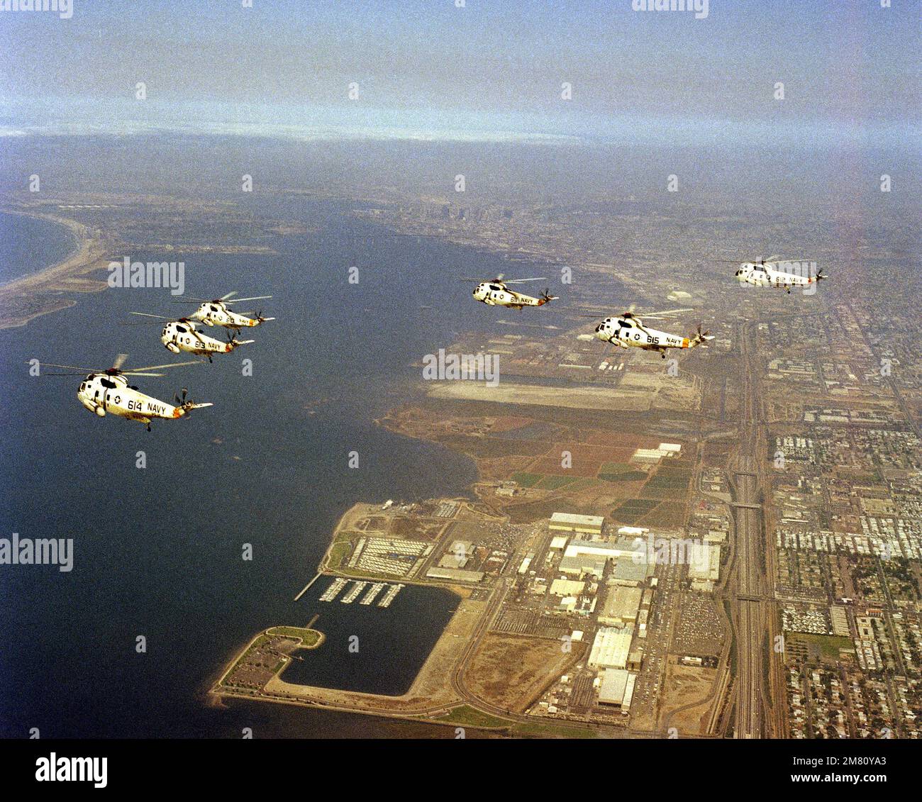 An air-to-air left side view of six SH-3 Sea King helicopters from ...