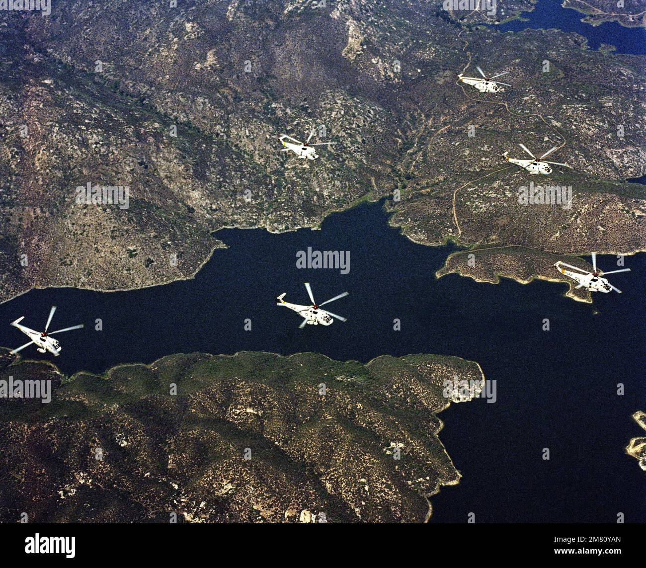 An air-to-air left front view of six SH-3 Sea King helicopters from ...