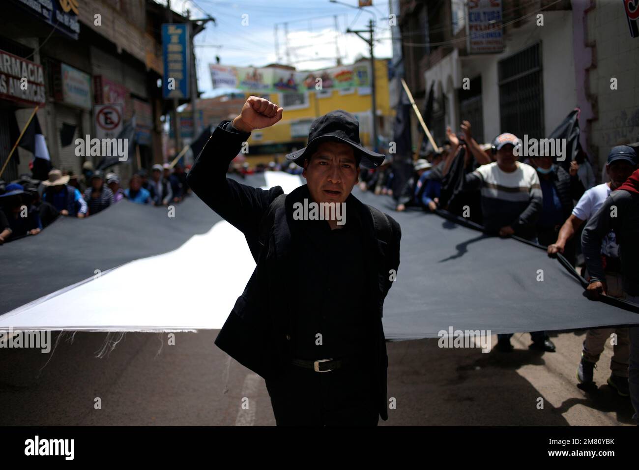 People march with a large Peruvian flag in black and white during a ...